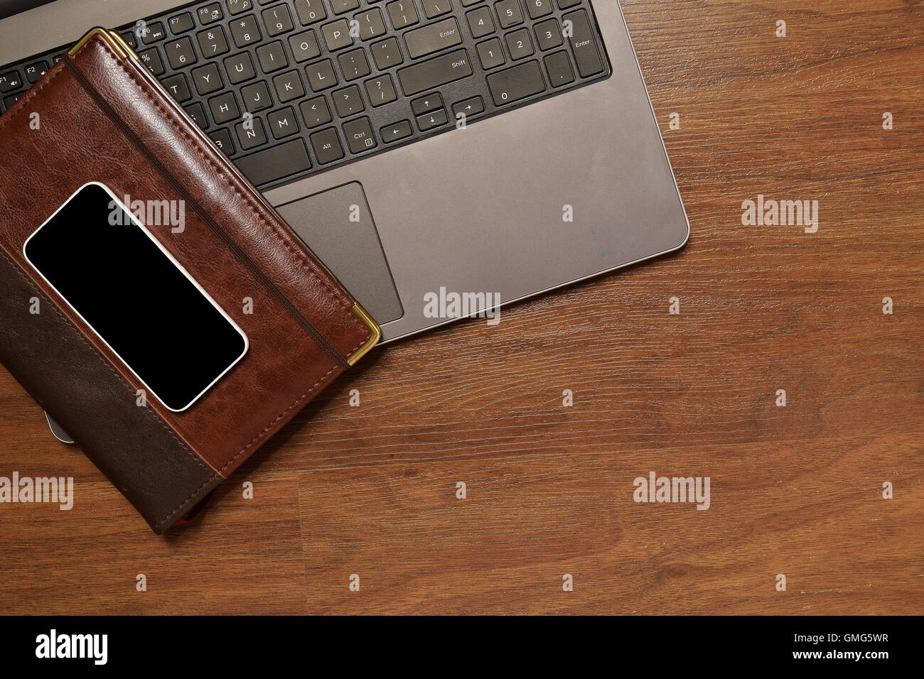 Top view of daily planner / diary, mobile phone and laptop computer, on ...