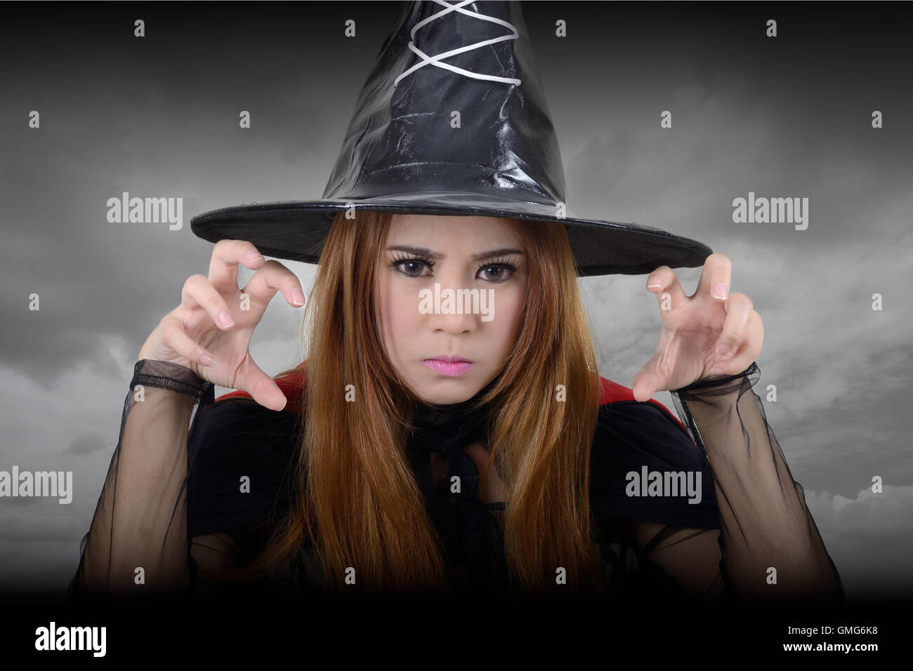 Witch looking toward and try to casts a spell in dark background Stock ...