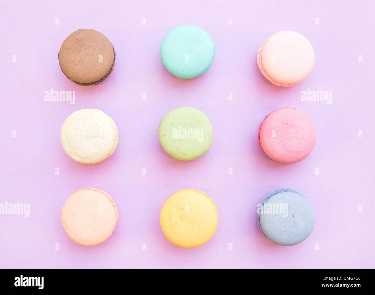 Sweet colorful French macaroon biscuits on pastel lilac background ...