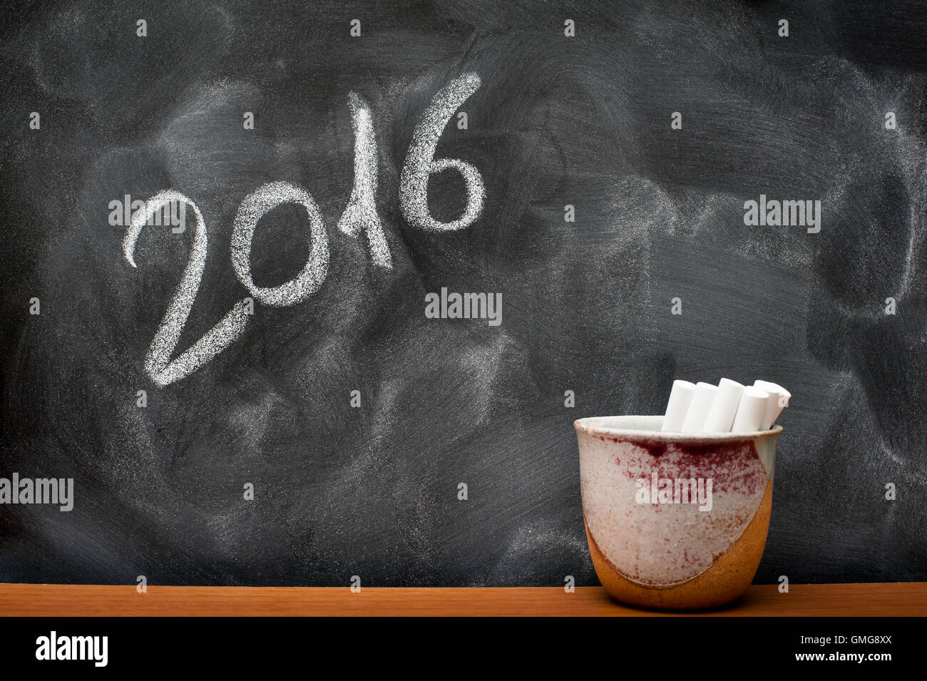 Number 2016 written on dusty school board with white color chalk and ...