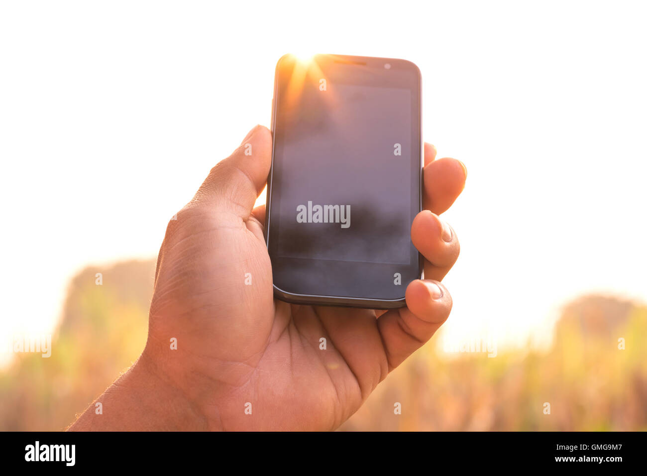 hand holding smartphone in outdoor that are sunlight Stock Photo - Alamy