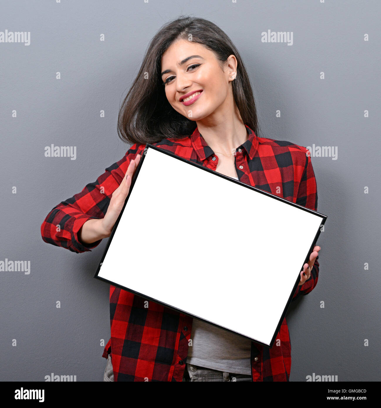 Portrait of smiling woman holding blank sign board.Studio portrait of ...