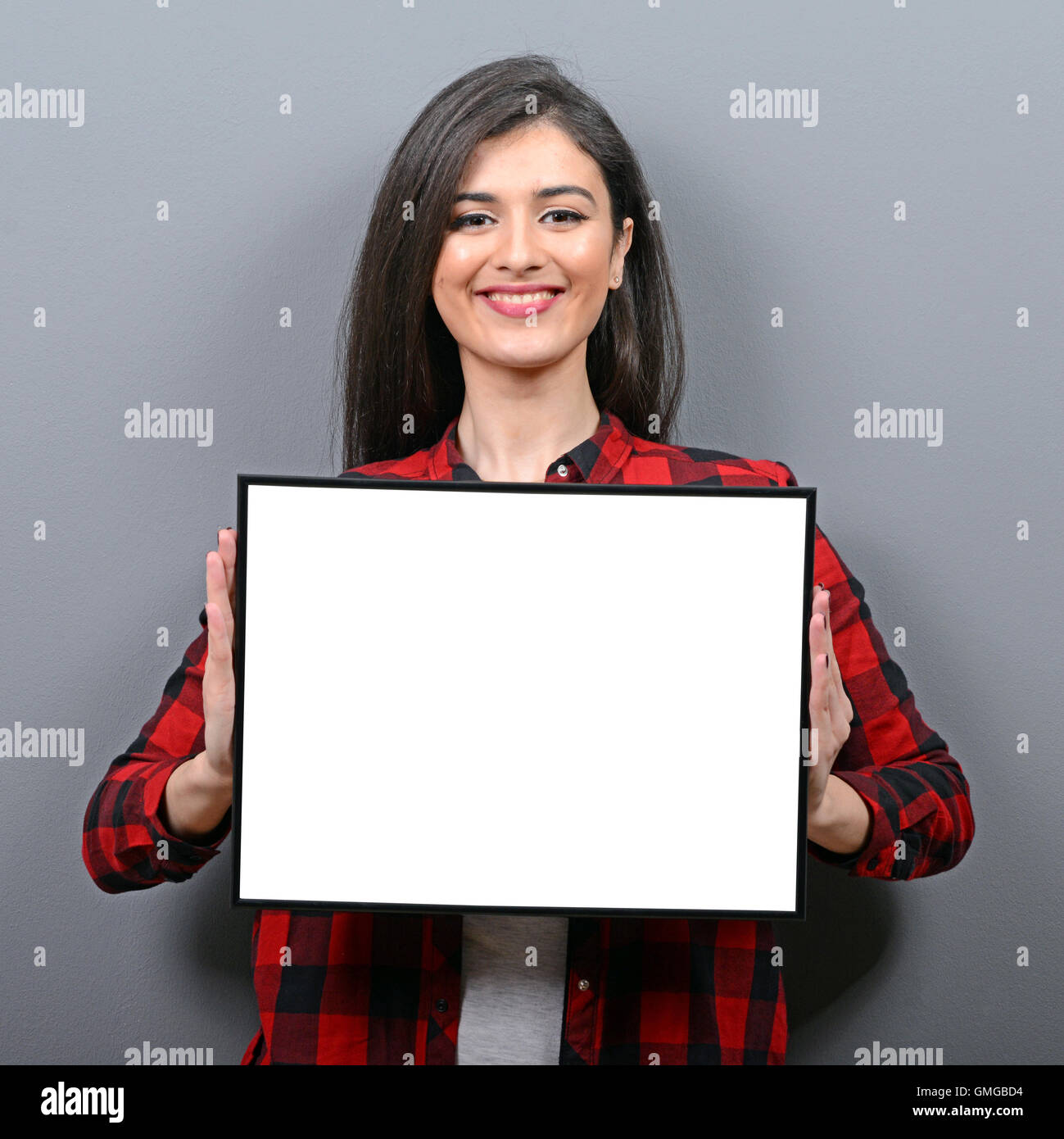 Portrait of smiling woman holding blank sign board.Studio portrait of ...