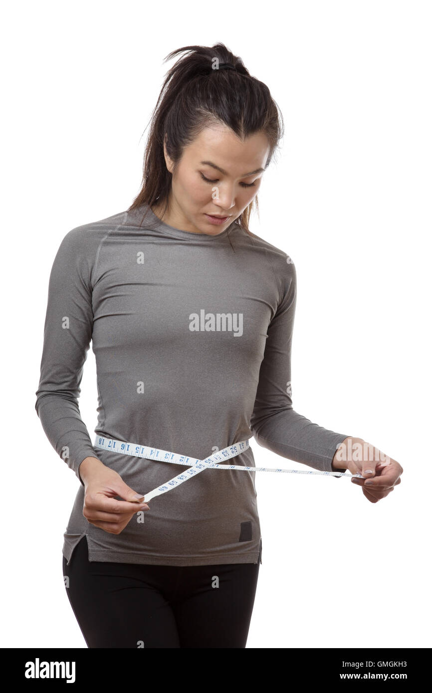 female fitness model with a tape measure around her waist Stock Photo ...