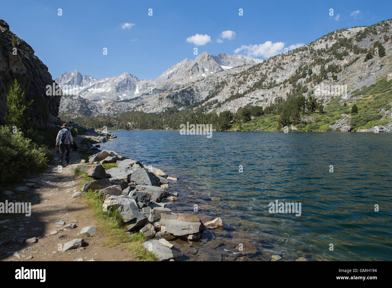 Hiker on the Little lakes valley trail at Long lake in the eastern ...