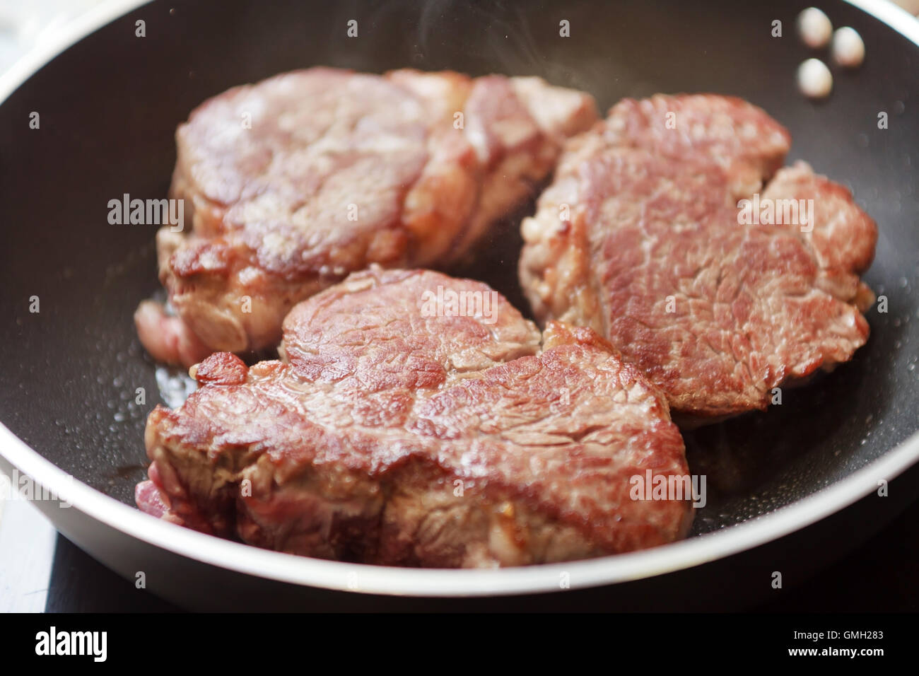 beef steak in a frying pan Stock Photo - Alamy