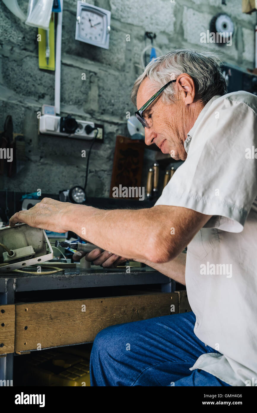 Senior mechanic working in garage Stock Photo - Alamy