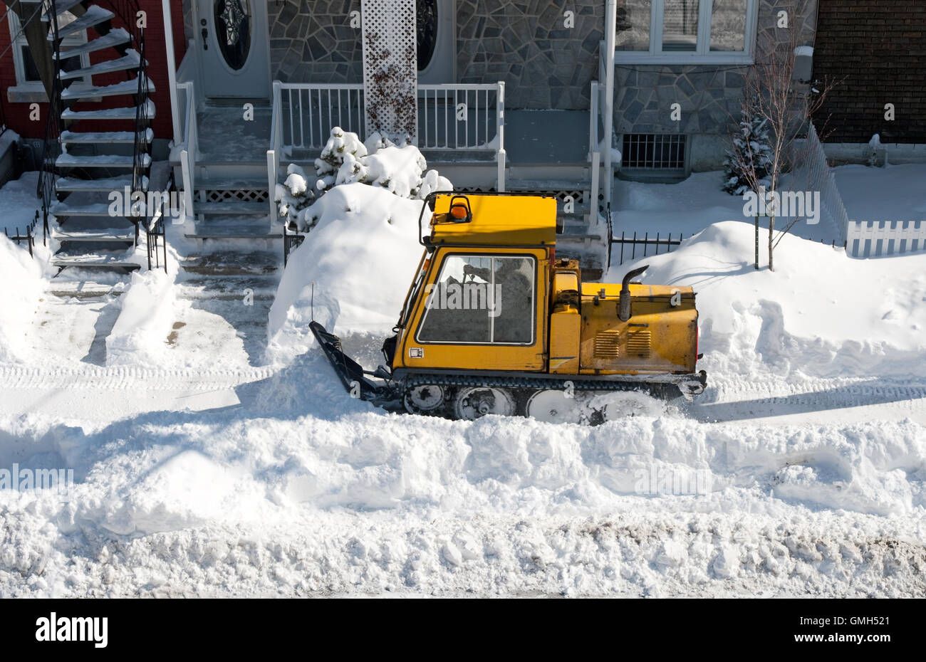 Yellow snowplough removing snow in the city Stock Photo - Alamy