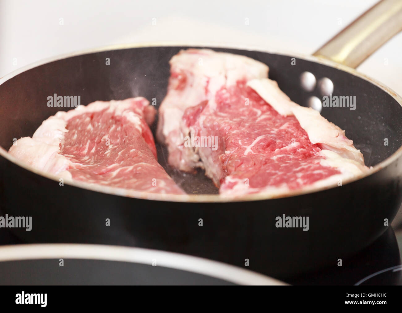 beef steak in a frying pan Stock Photo - Alamy