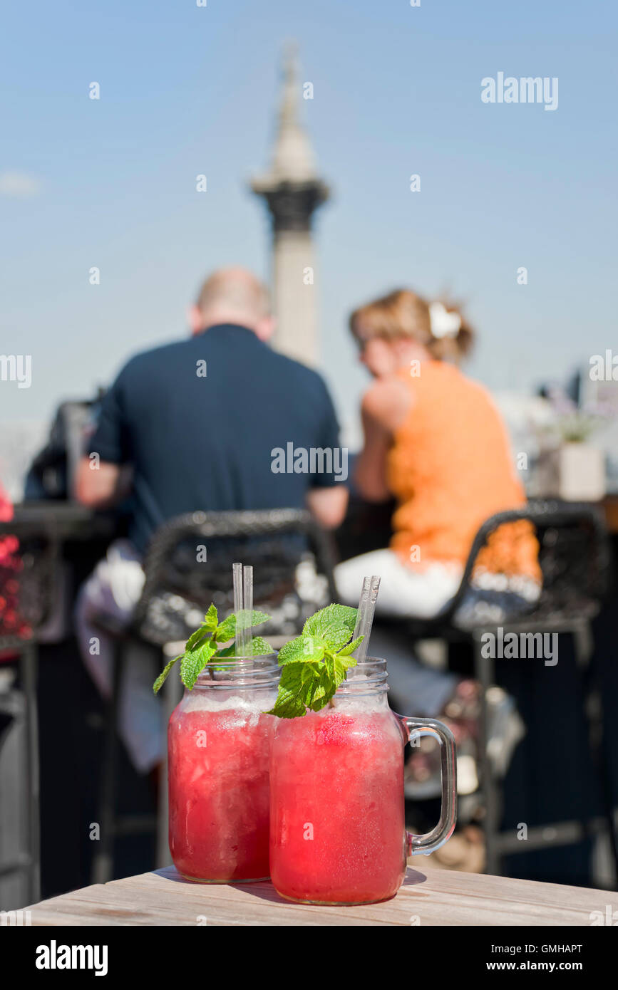 Vertical portrait of cocktails on a table of a rooftop bar overlooking ...