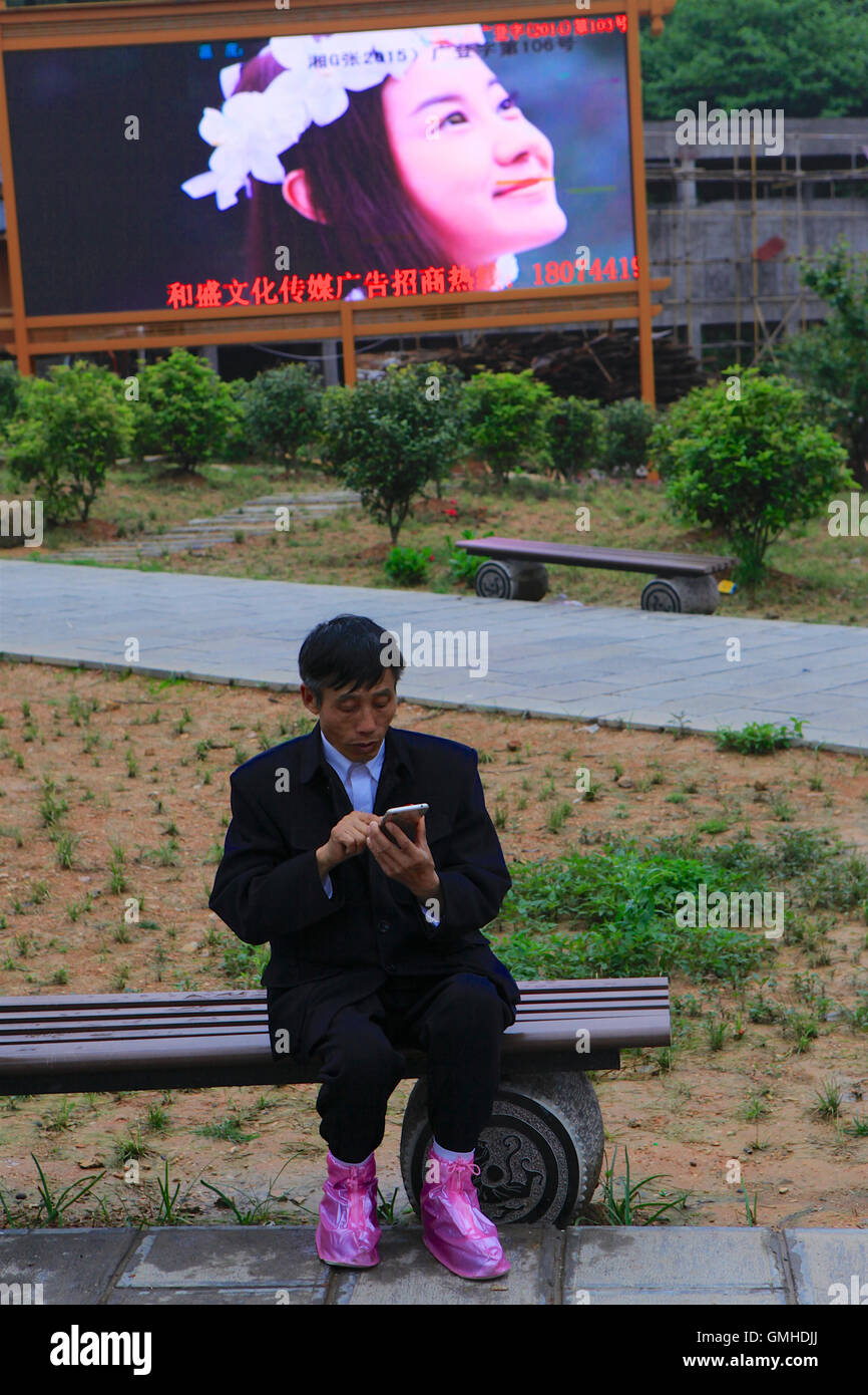 Tourist man with cell and rainy shoes at Zhangjiajie National Forest ...
