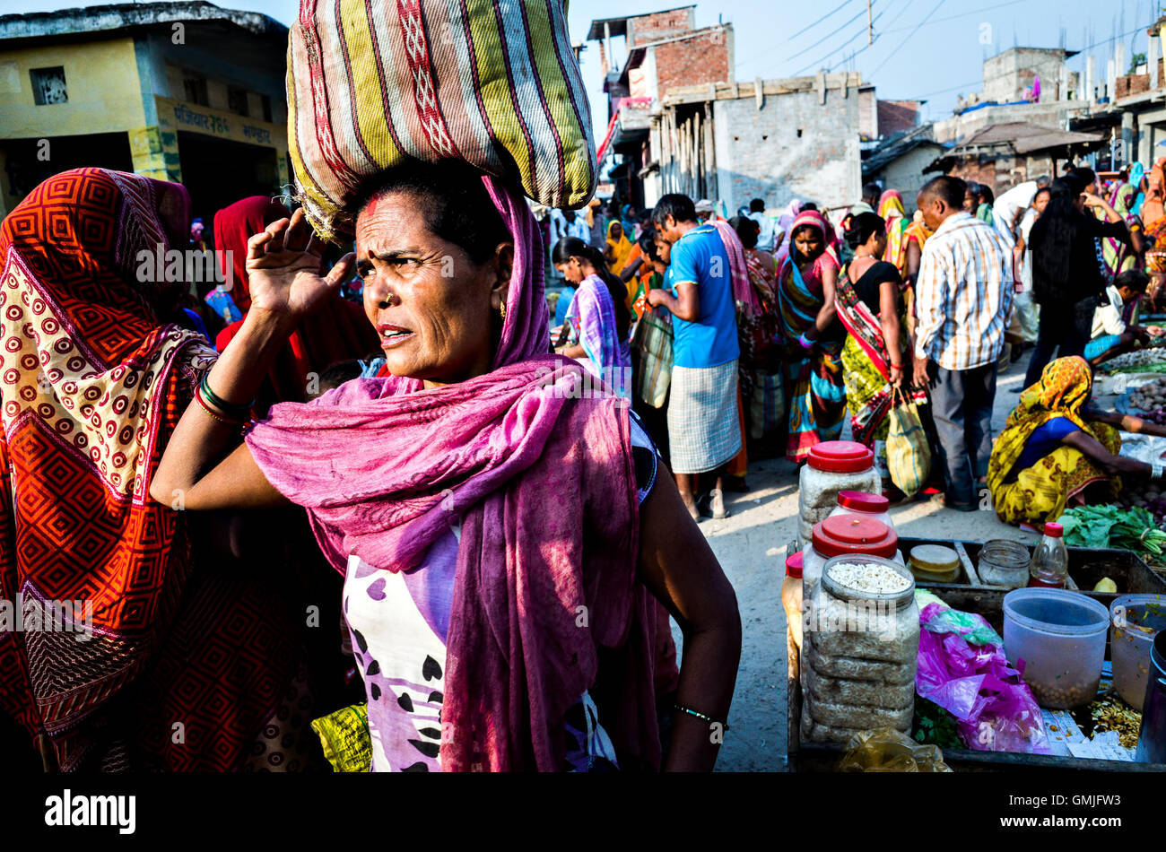 a woman carrying necessities bought from a local market in Dhanusha ...