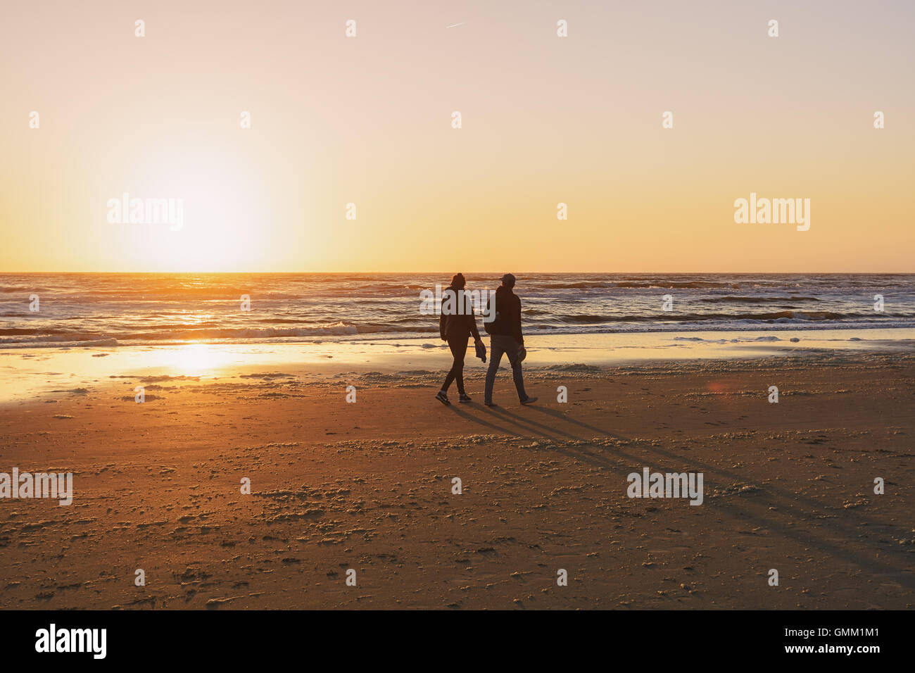 Evening beach with people watching the sunset Stock Photo - Alamy
