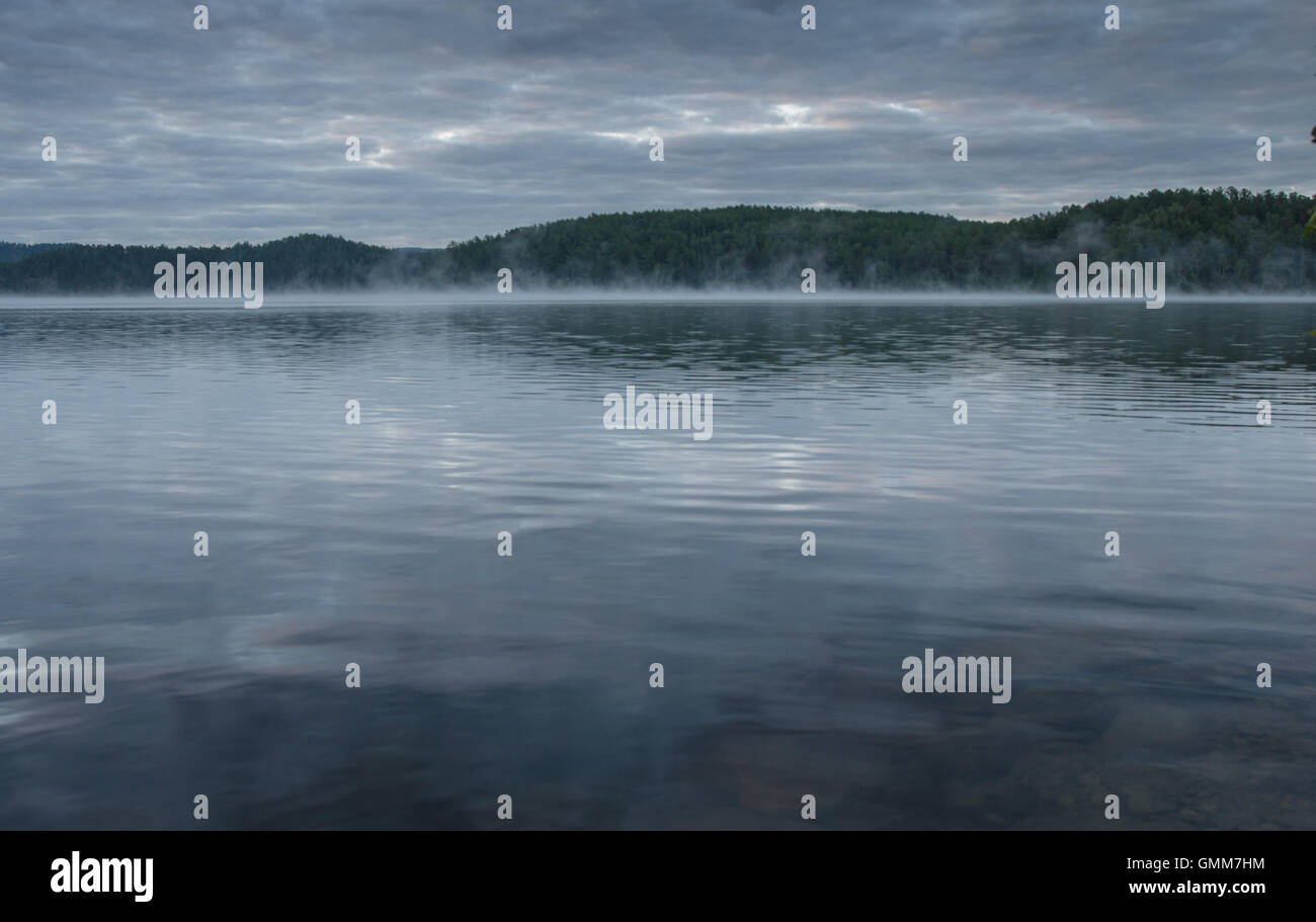 Morning mist rises above the surface of forest lake. Landscape Stock ...