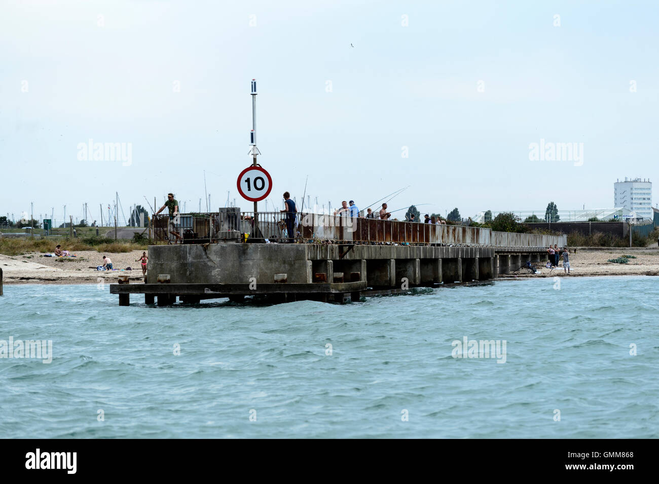 Langstone Harbour entrance, pier with fishermen Stock Photo - Alamy