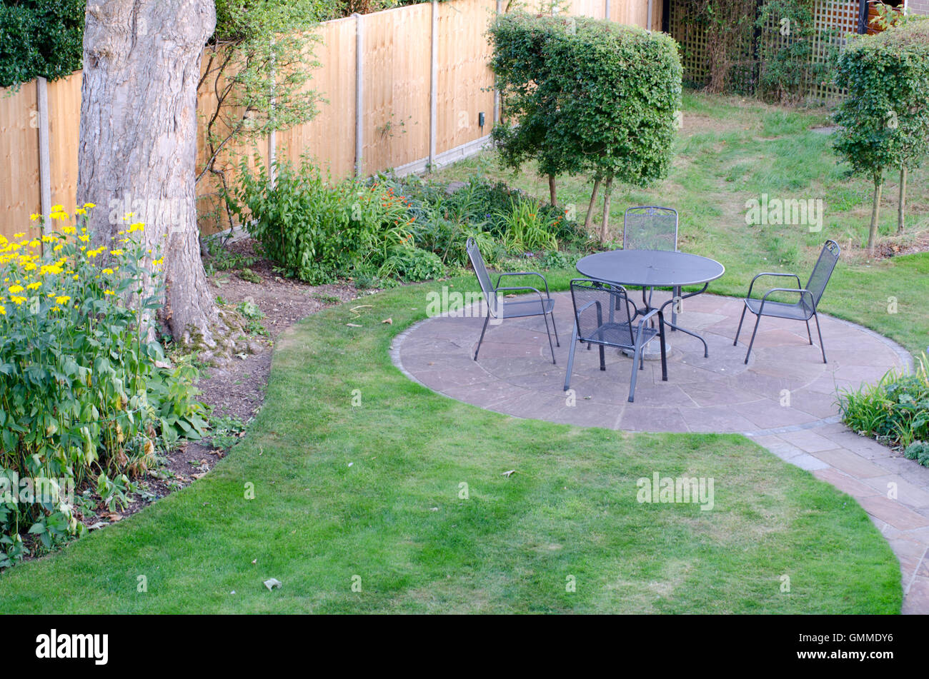 Circular garden patio with table and chairs Stock Photo - Alamy