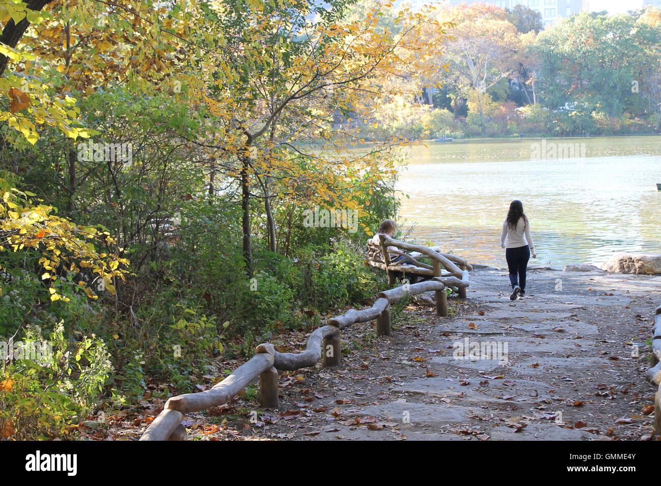 Woman walking in nature towards a lake Stock Photo - Alamy