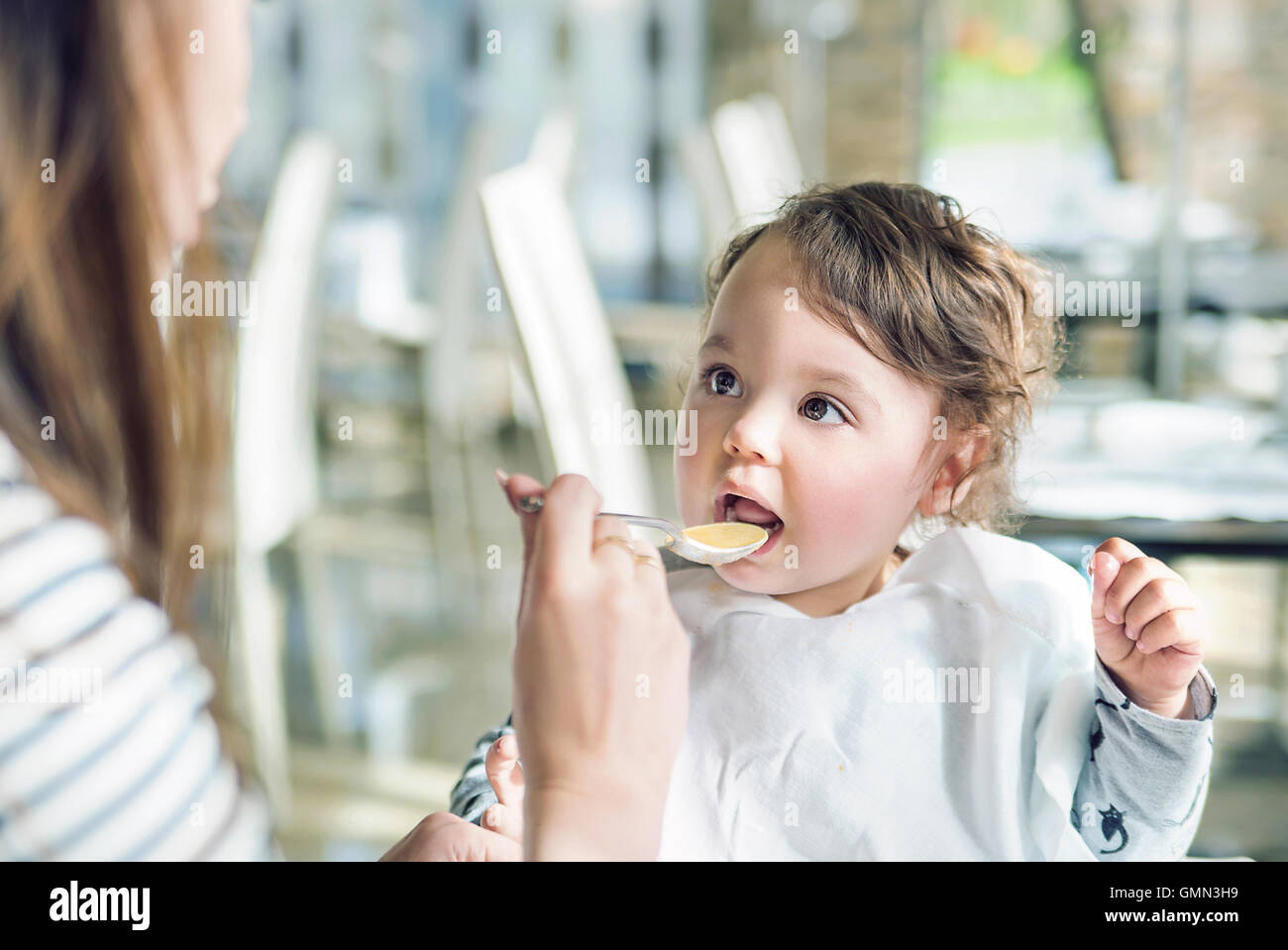 Portrait of a cute baby being fed by her mother Stock Photo - Alamy