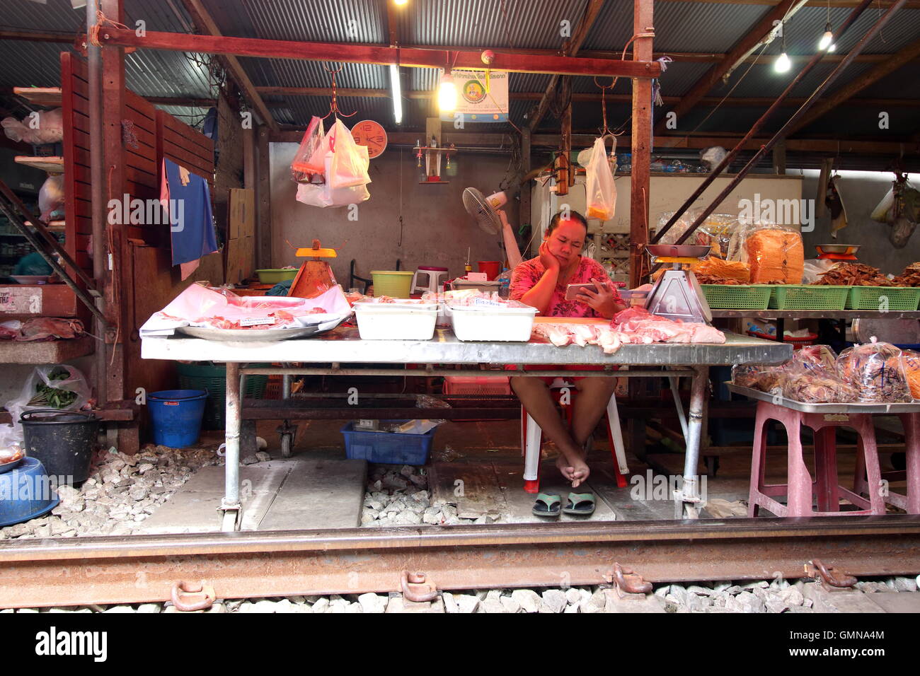 A lady pork seller manning her stall which is set up right next to the ...