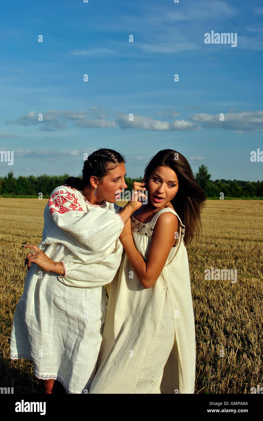 Two girls in a rural clothing talking on the phone Stock Photo - Alamy