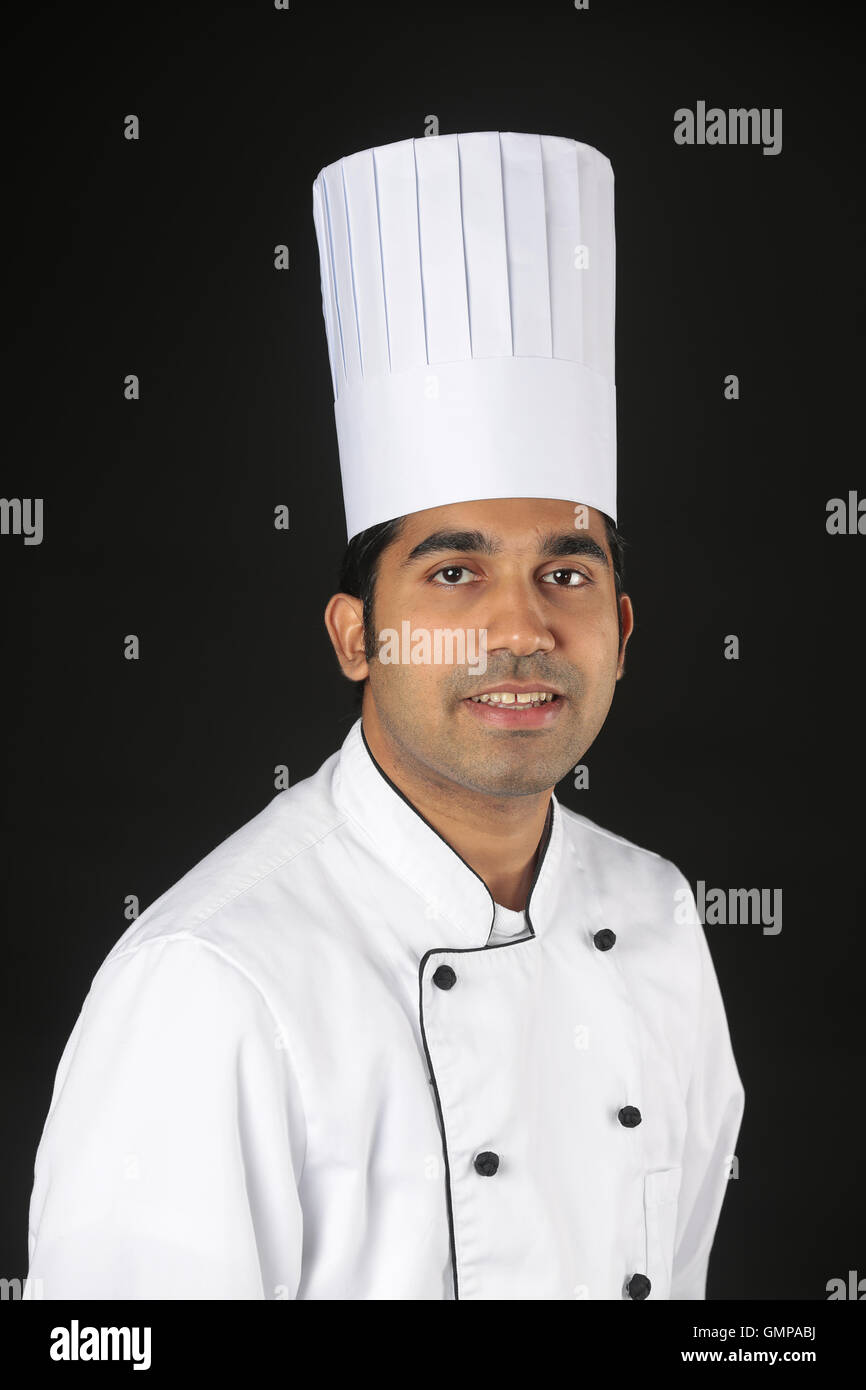 cooking, profession and people concept - happy male indian chef in ...