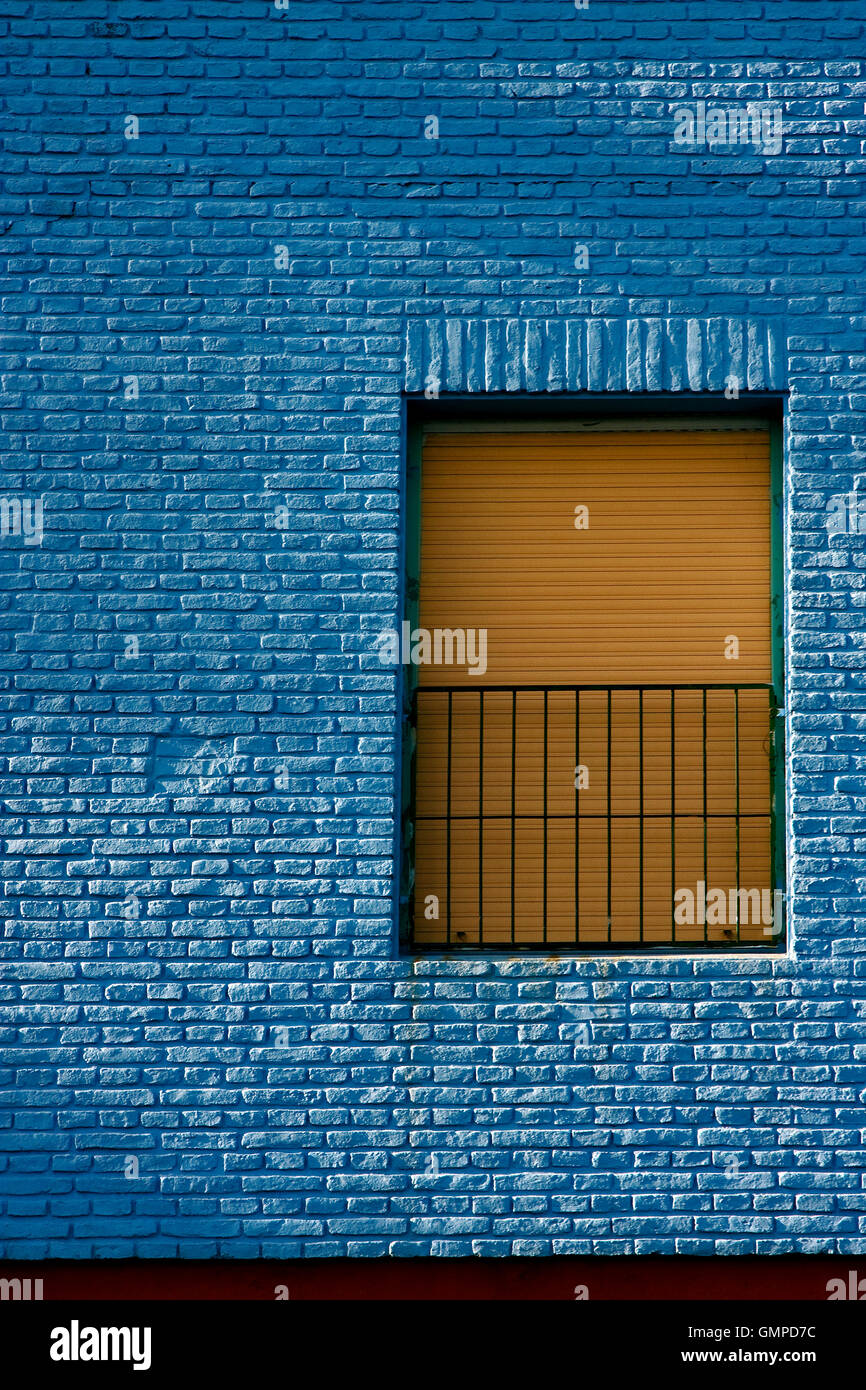 old yellow window in light blue wall Stock Photo - Alamy