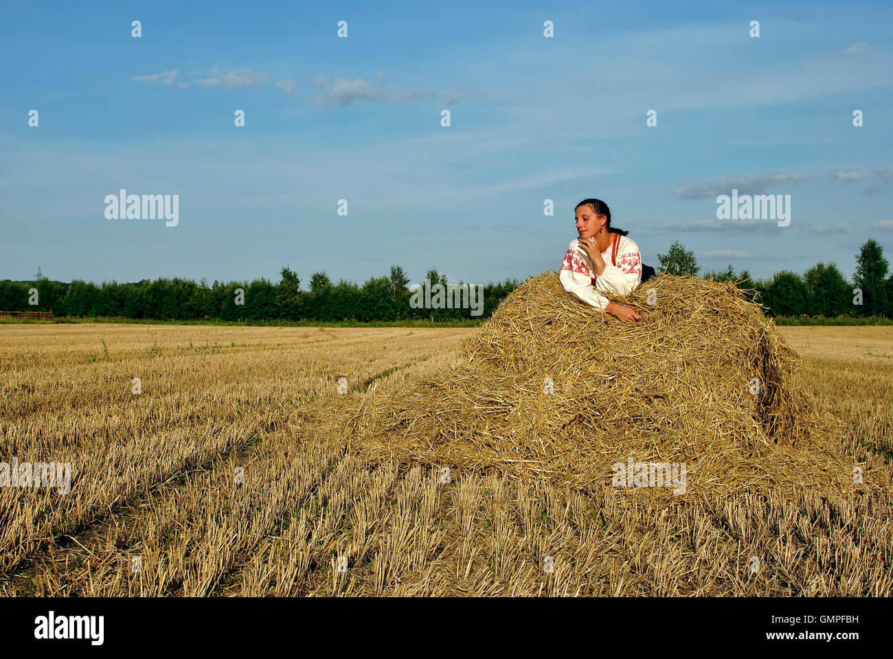 girl in traditional Russian costume lying on a haystack Stock Photo - Alamy
