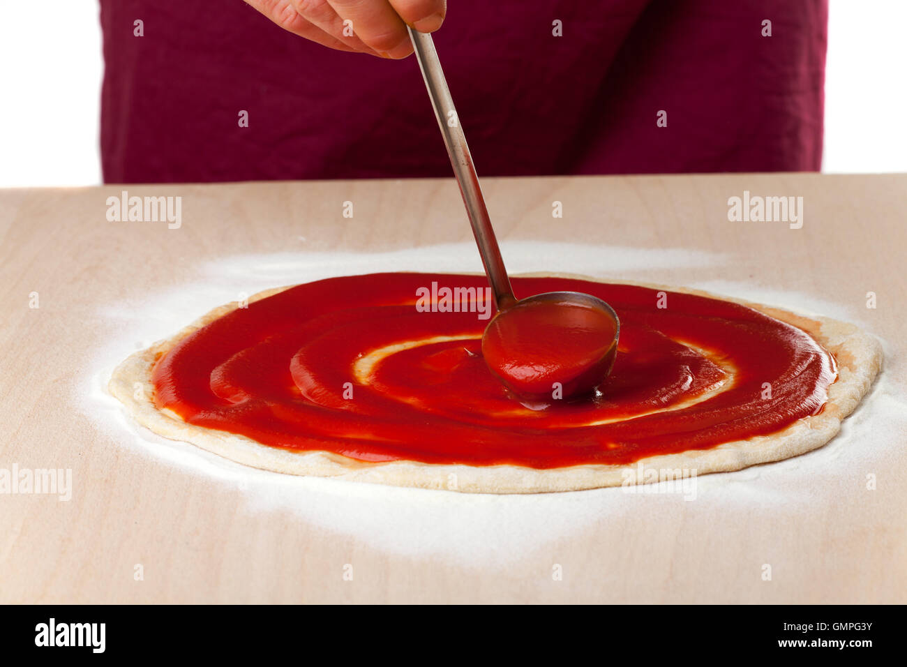 pouring tomato sauce on a pizza Stock Photo - Alamy