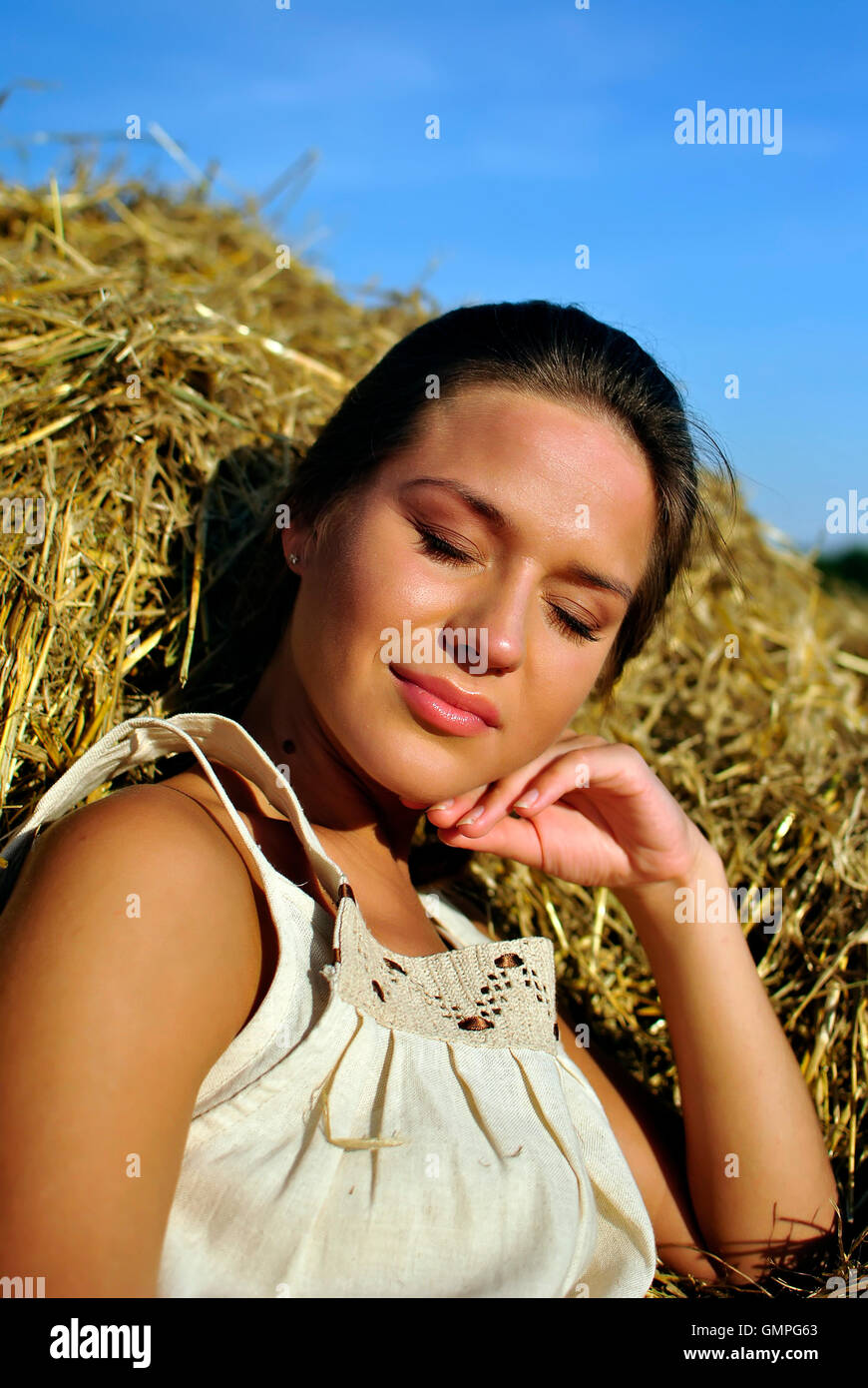 girl in traditional Russian costume resting on a haystack Stock Photo ...