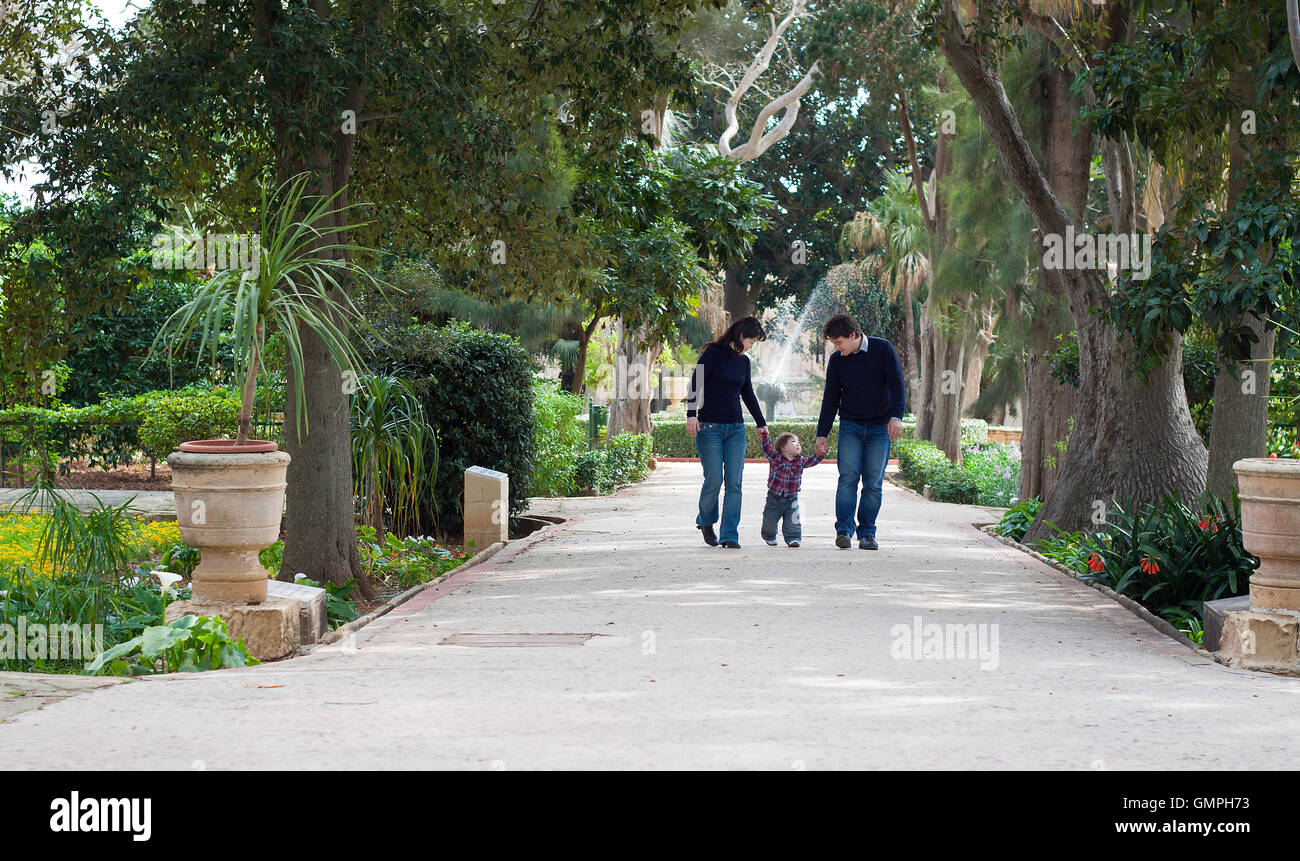 Child learning to walk with parents Stock Photo - Alamy
