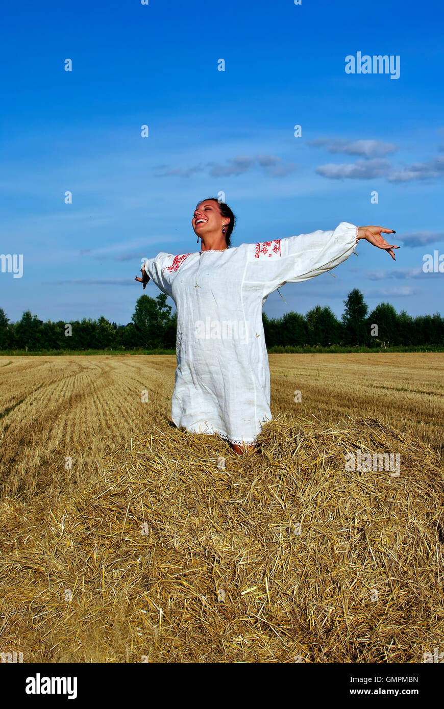 girl in traditional Russian costume sitting on a haystack Stock Photo ...