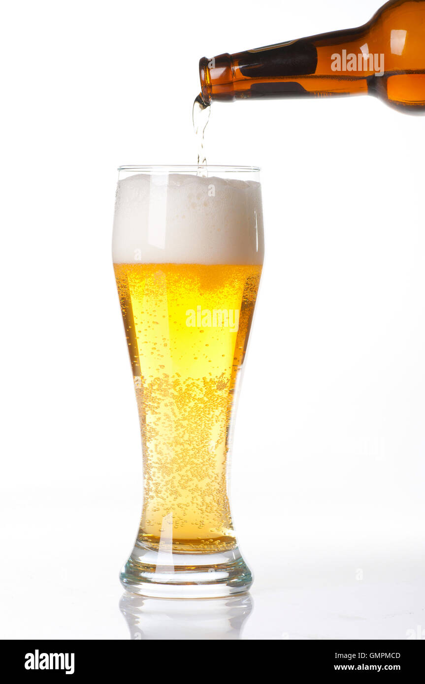 Beer pouring from bottle into glass isolated on white Stock Photo - Alamy