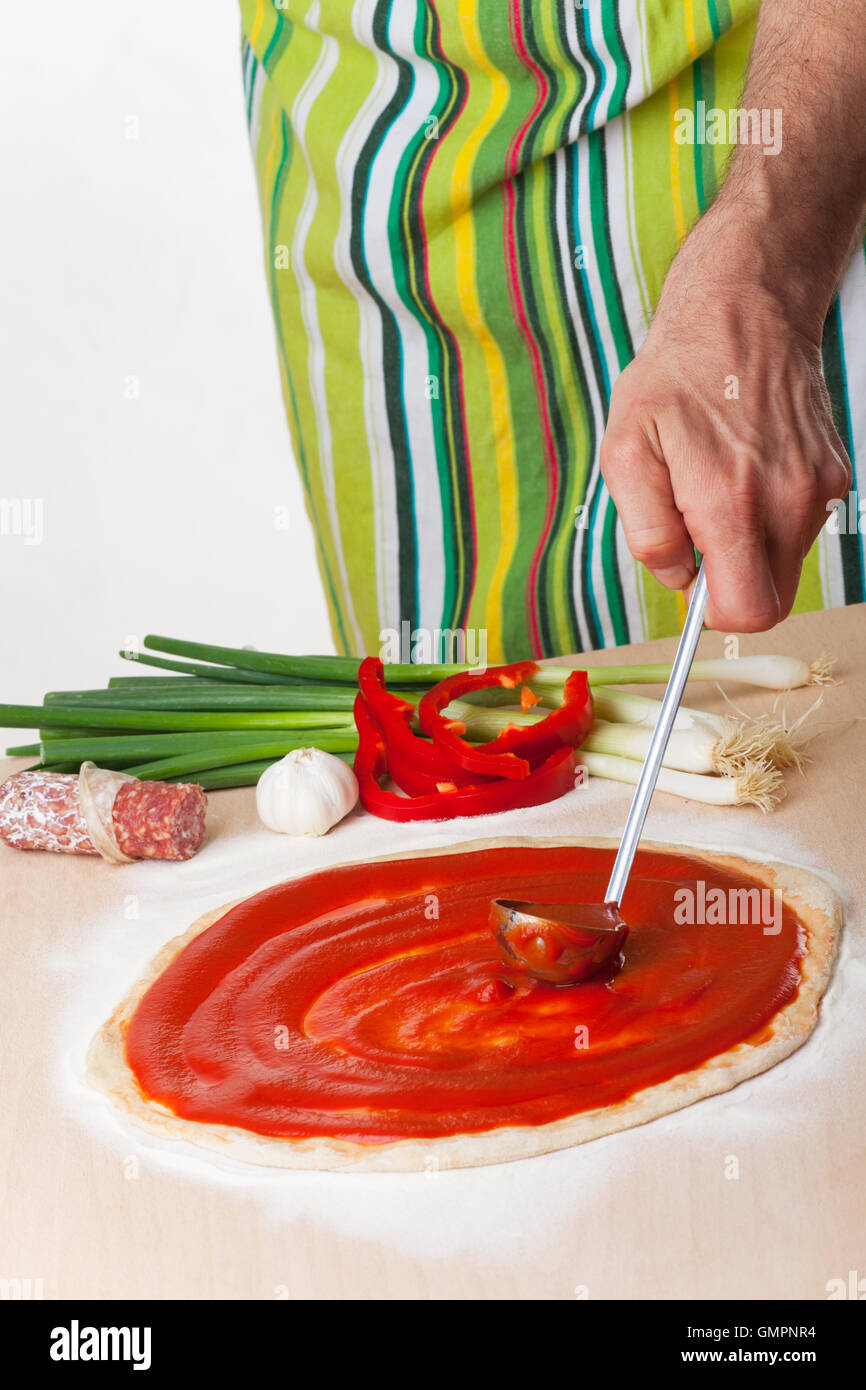 pouring tomato sauce on a pizza Stock Photo - Alamy