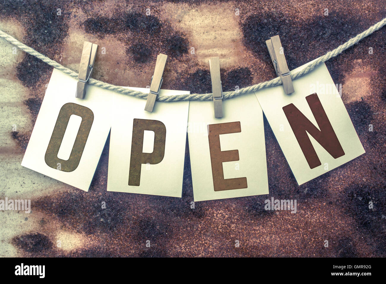 The word "OPEN" stamped on cards and pinned to an old piece of twine ...