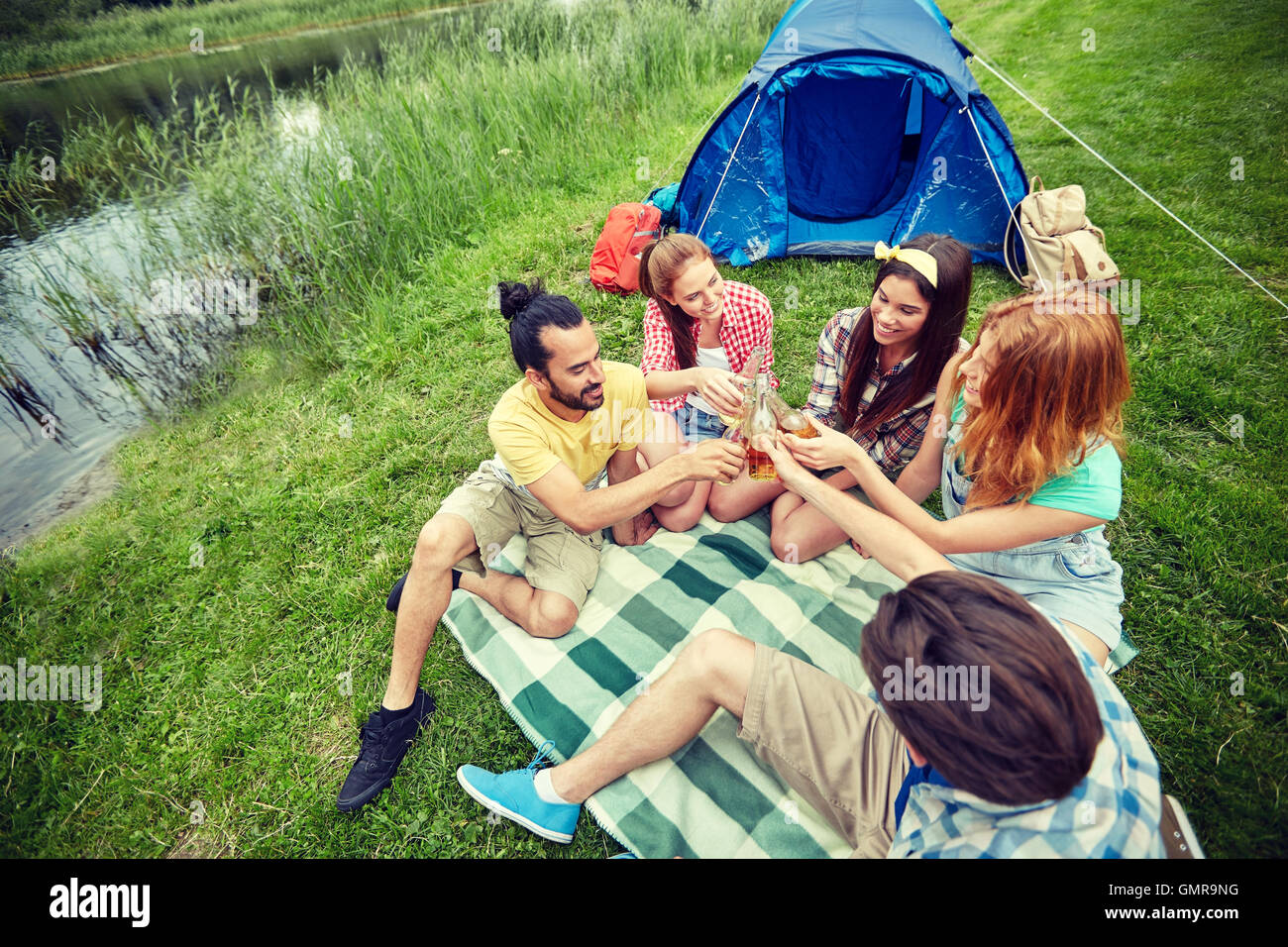 happy friends with tent and drinks at campsite Stock Photo - Alamy