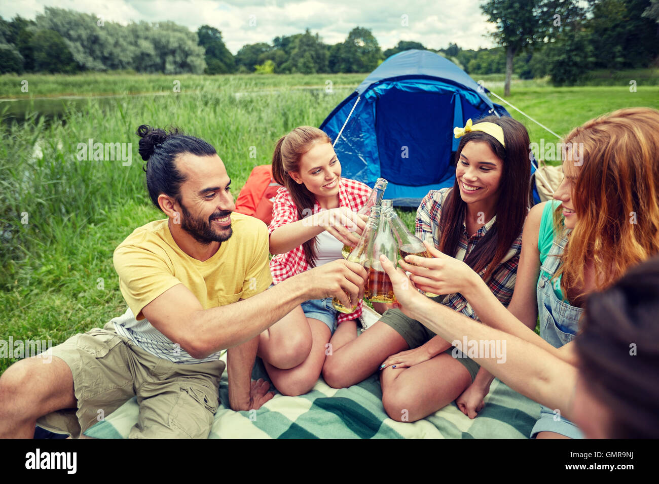 happy friends with tent and drinks at campsite Stock Photo - Alamy