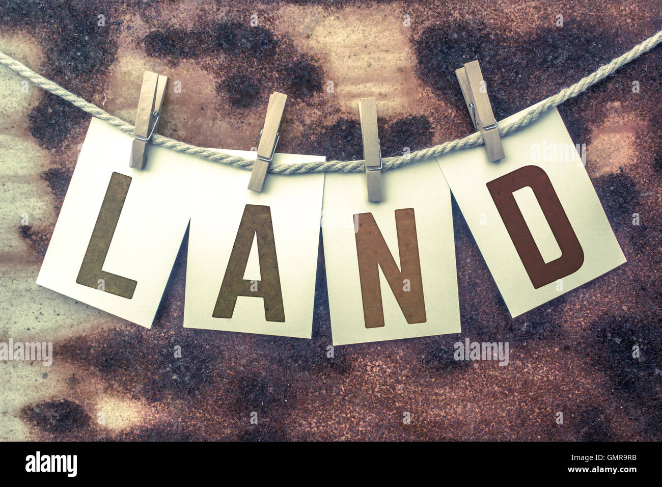 The word "LAND" stamped on cards and pinned to an old piece of twine ...