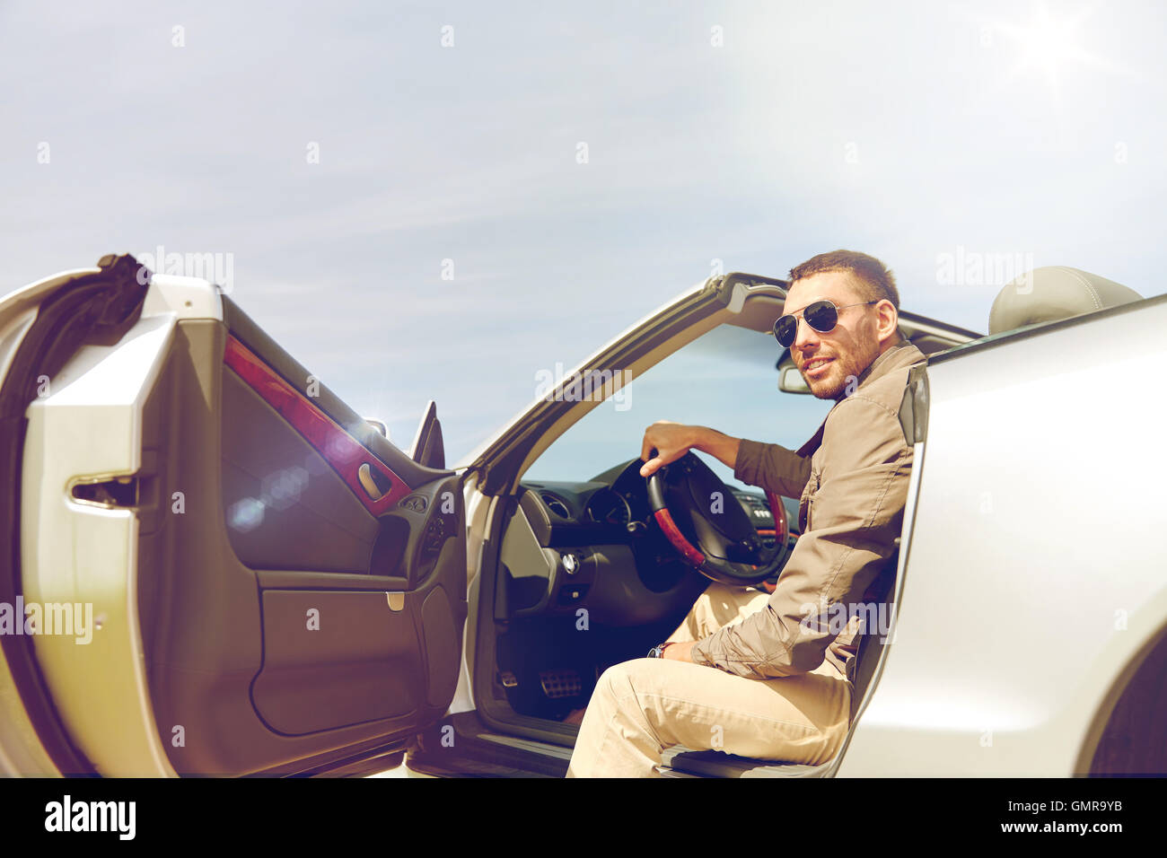 happy man opening door of cabriolet car outdoors Stock Photo - Alamy