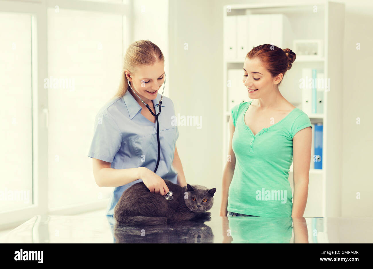 happy woman with cat and doctor at vet clinic Stock Photo - Alamy