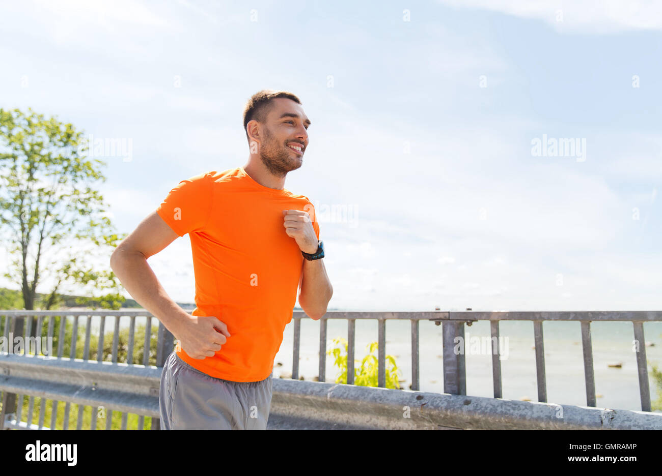 smiling young man running at summer seaside Stock Photo - Alamy