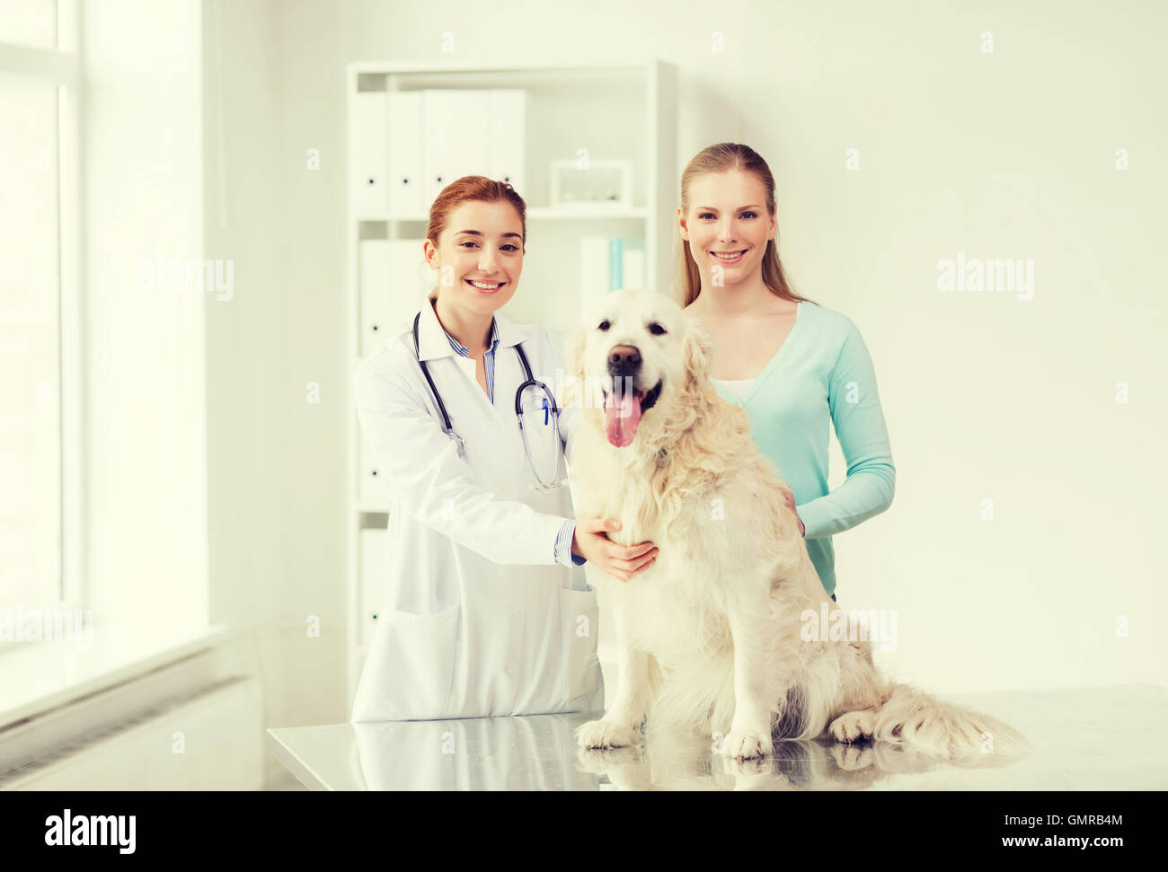 happy woman with dog and doctor at vet clinic Stock Photo - Alamy