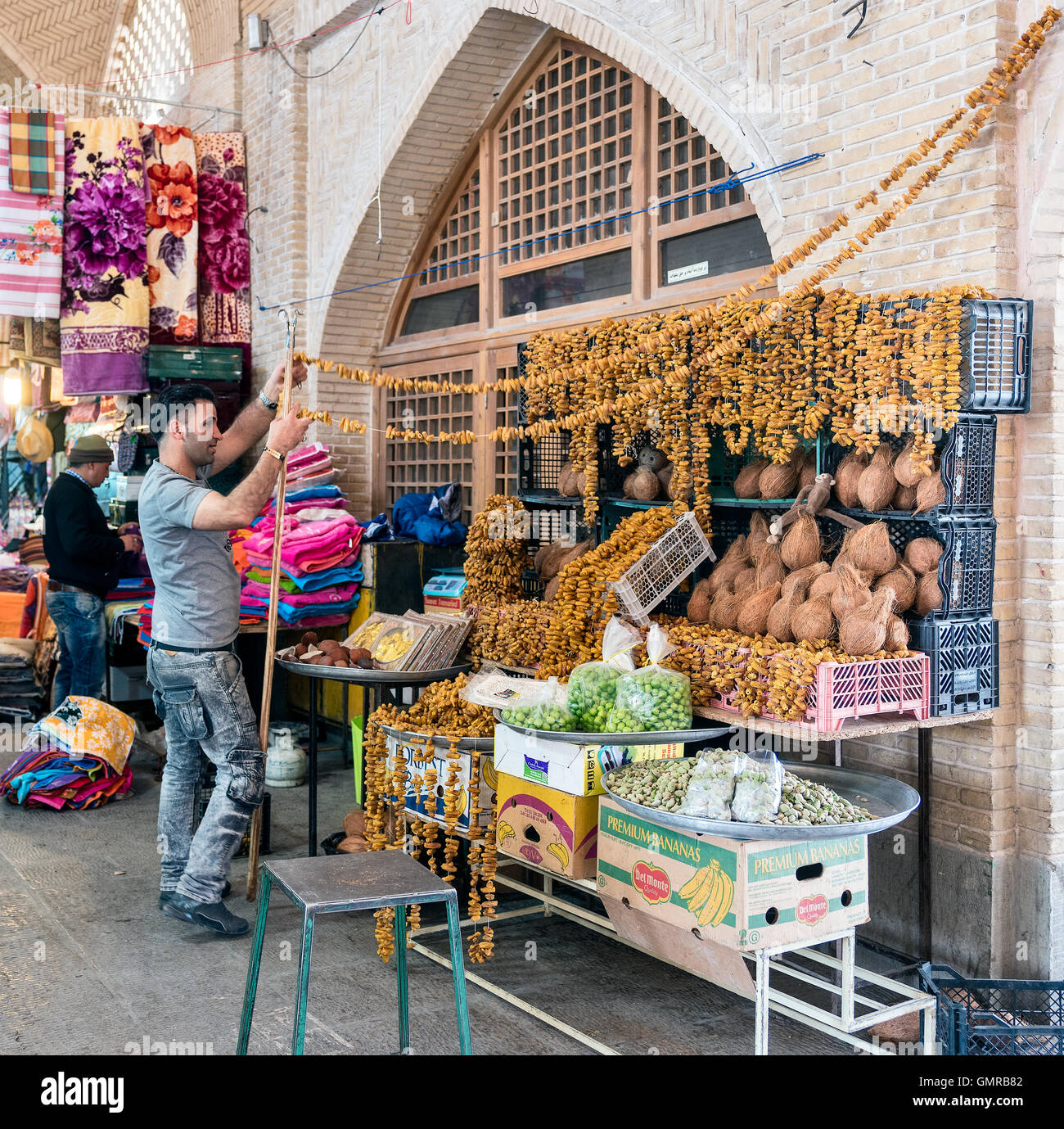Merchant decorates his shop with dried fruit in the Grand Bazaar ...
