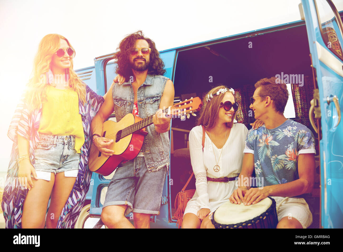 happy hippie friends playing music over minivan Stock Photo - Alamy