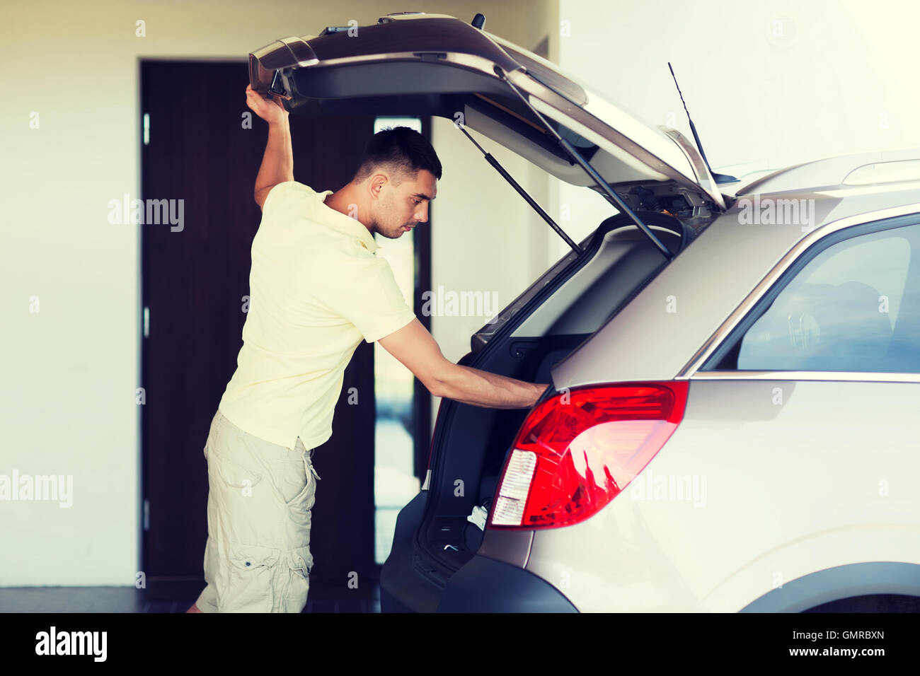 young man with open car trunk at parking space Stock Photo - Alamy