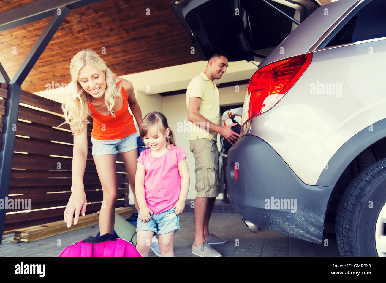 happy family packing things to car at home parking Stock Photo - Alamy