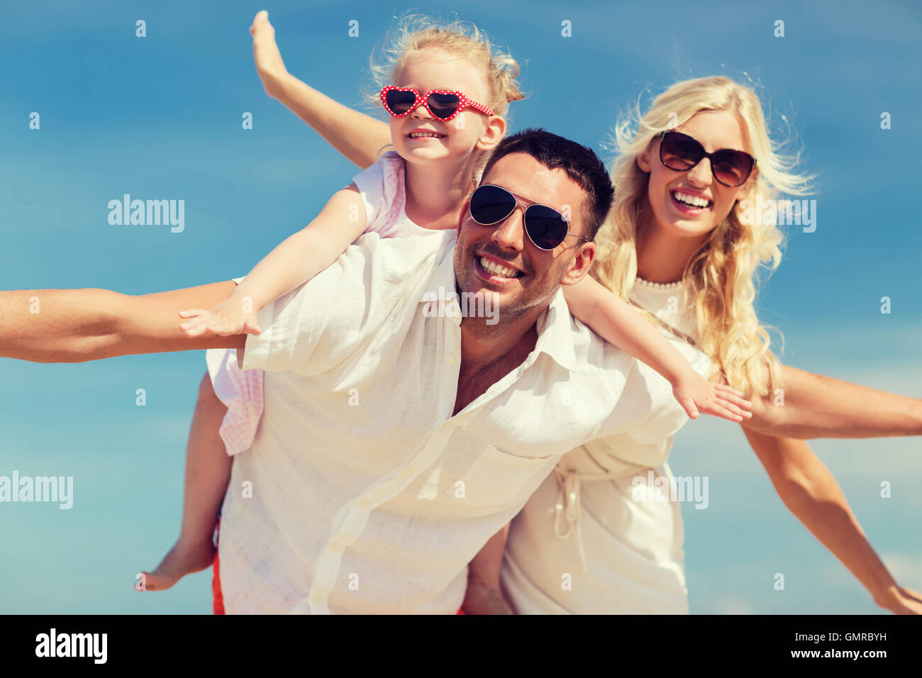 happy family having fun over blue sky background Stock Photo - Alamy