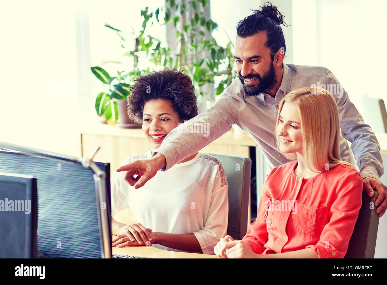 happy creative team with computer in office Stock Photo - Alamy