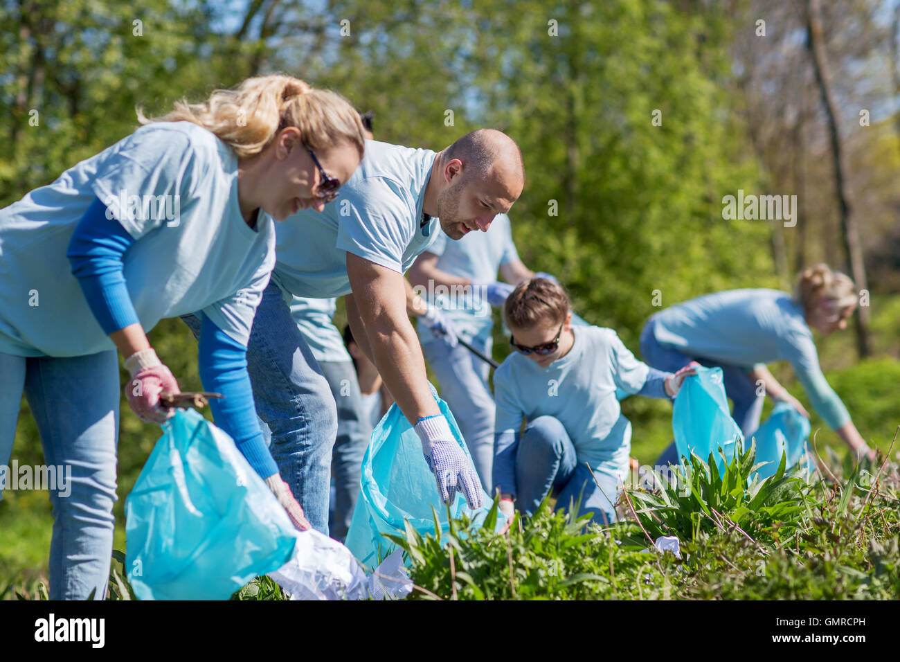 volunteers with garbage bags cleaning park area Stock Photo - Alamy
