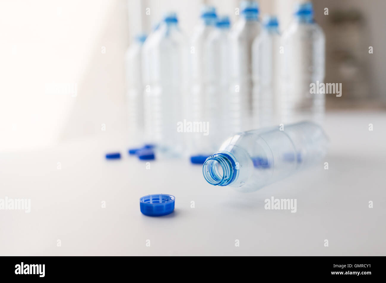close up of empty water bottles and caps on table Stock Photo - Alamy