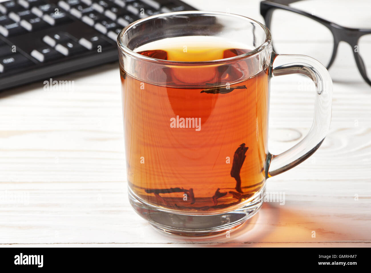 Cup of tea and keyboard on wooden background Stock Photo - Alamy